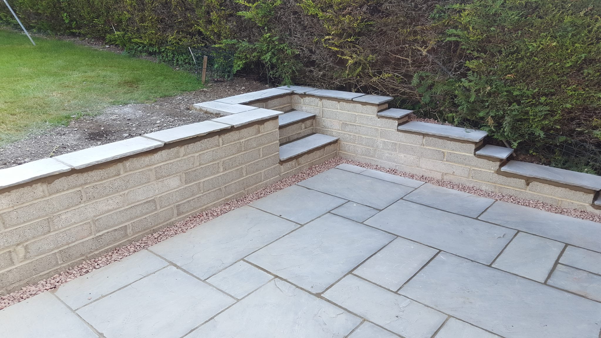 Before and after of a patio/retaining wall in Woodstock | Baker Landscaping